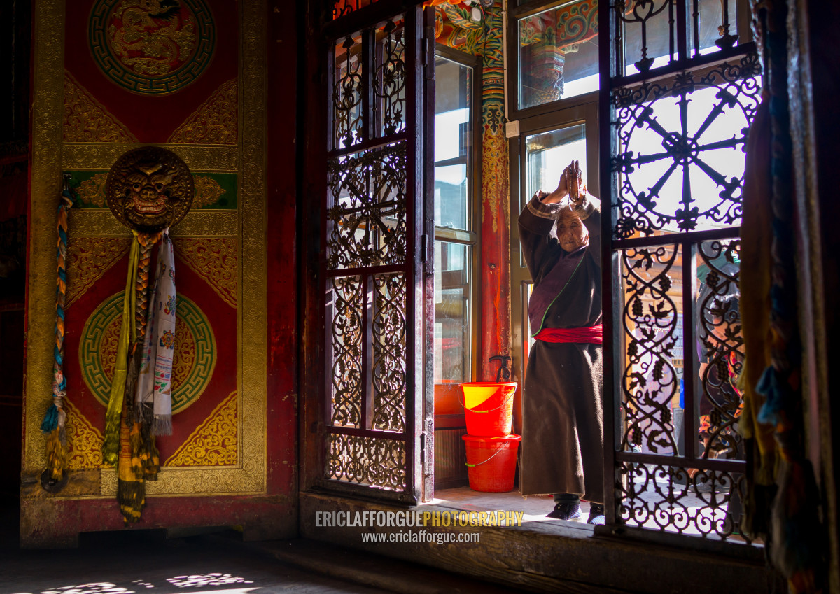 ERIC LAFFORGUE PHOTOGRAPHY - Tibetan woman praying at the entrance of a temple in Rongwo ...
